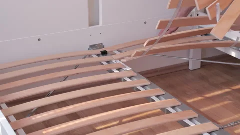 Finishing a new bed frame with bed slats... | Stock Video | Pond5
