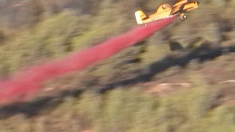 Fire fighting plane fly low and spray fi... | Stock Video | Pond5