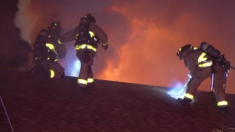Firefighters cut holes in roof of house ... | Stock Video | Pond5