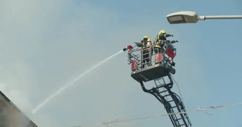 Firefighters extinguishing fire on tall ... | Stock Video | Pond5