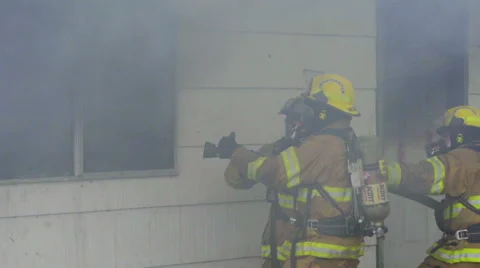 Firefighters get ready to spray burning ... | Stock Video | Pond5