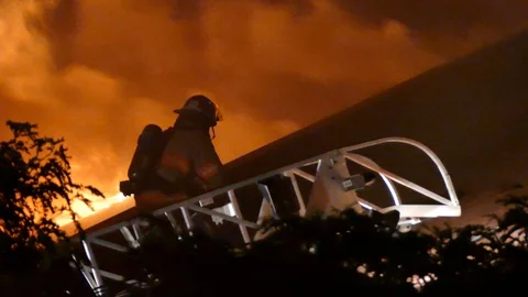 Fireman sitting atop big ladder at night... | Stock Video | Pond5
