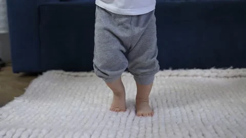 First steps. Kid learns to walk at home.... | Stock Video | Pond5