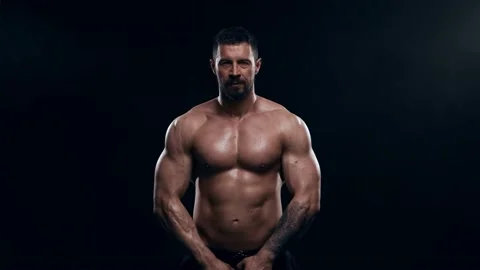 Fit and sporty bodybuilder over black ba... | Stock Video | Pond5