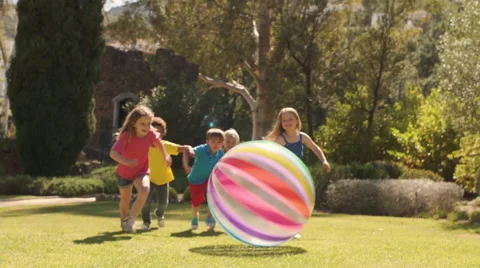 Five children pushing beach ball towards... | Stock Video | Pond5