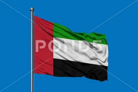 Flag of United Arab Emirates waving in the wind against deep blue sky ...