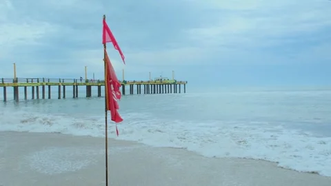 Flag in the wind, pier goes into the oce... | Stock Video | Pond5