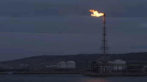 Flare stack of LNG refinery on sea shore... | Stock Video | Pond5