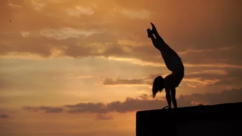 Flexible girl doing handstand on sky bac... | Stock Video | Pond5