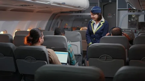 Flight attendant assisting passengers to... | Stock Video | Pond5