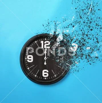 Photograph: Flow of time. Analog clock dissolving on light blue ...