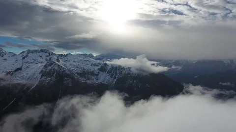 Flying in clouds between snow-capped mou... | Stock Video | Pond5