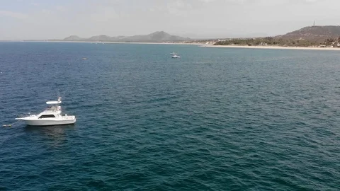 Flying over a boat in the ocean with mou... | Stock Video | Pond5