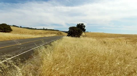 Flying over dry grass and a highway in C... | Stock Video | Pond5