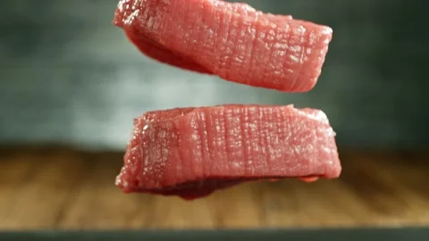 Flying pieces of raw beef steaks falling... | Stock Video | Pond5
