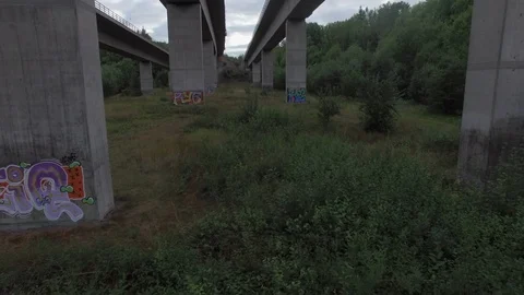 Flying under bridge. Pillars with graffi... | Stock Video | Pond5