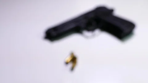 Focus to pistol and bullet casings on wh... | Stock Video | Pond5
