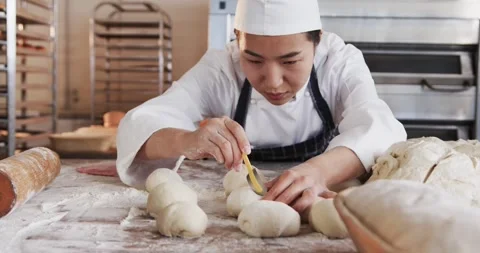 Focused asian female baker working in ba... | Stock Video | Pond5