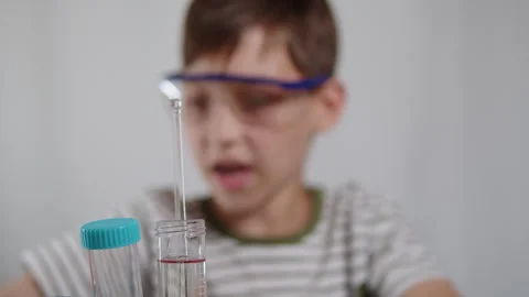 Focused boy watching test tube reaction ... | Stock Video | Pond5