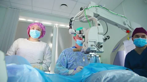 Focused ophthalmic surgeon looks into mi... | Stock Video | Pond5