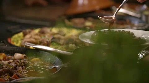 Food is being spooned from the trays bel... | Stock Video | Pond5