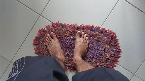 A foot mat placed on the white ceramic f... | Stock Video | Pond5
