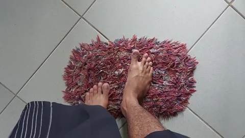 A foot mat placed on the white ceramic f... | Stock Video | Pond5