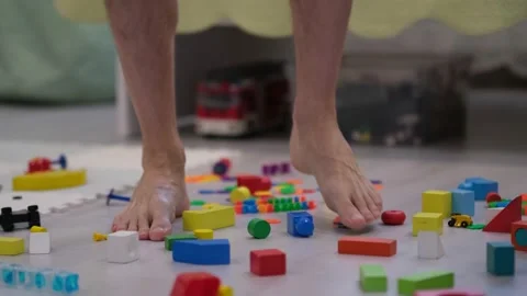 Foot stepping on children's toys. Scatte... | Stock Video | Pond5