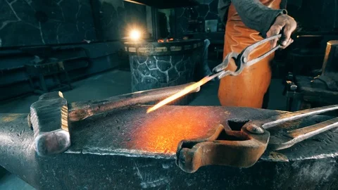 Forge worker puts hot knife on anvil. | Stock Video | Pond5