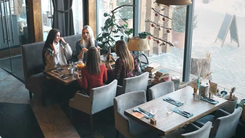 Four smiling friends sitting at cafe and... | Stock Video | Pond5