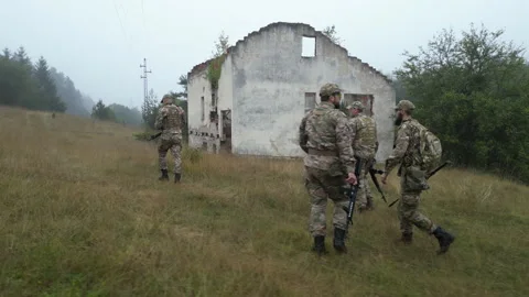 Four Soldiers Walking by a Ruined House ... | Stock Video | Pond5