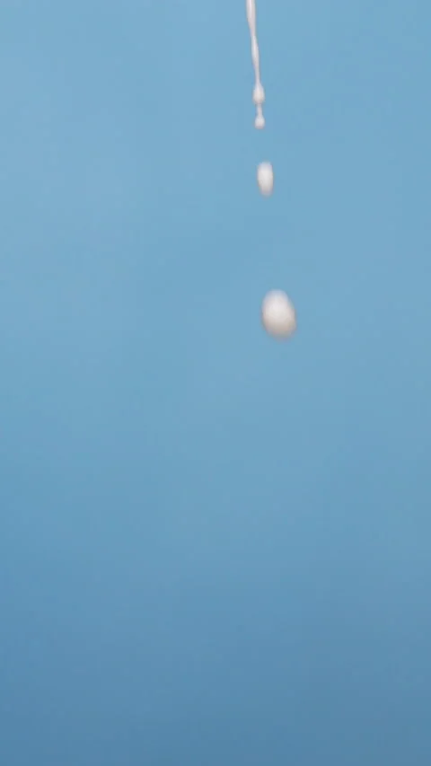 Fresh milk drops falling on blue backgro... | Stock Video | Pond5