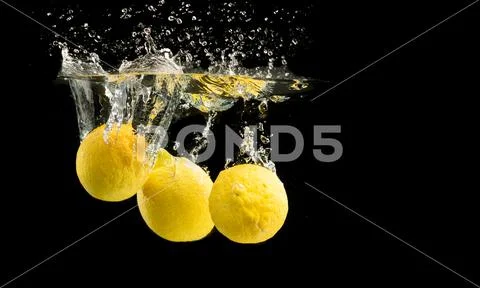 Fresh yellow lemons in water splash on black background Stock Image #155659206