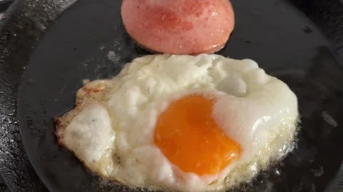 Fried eggs in a frying pan, cooking brea... | Stock Video | Pond5