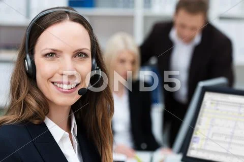 Photograph: Friendly attractive young call centre operator #29152547