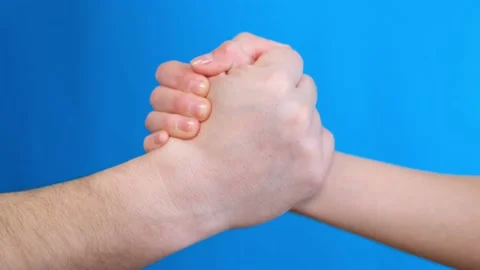 Friendly handshake on a light blue backg... | Stock Video | Pond5