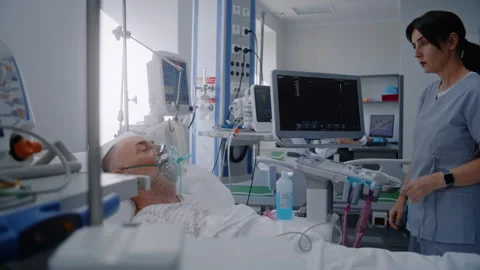 Friendly nurse adjusts life support mach... | Stock Video | Pond5