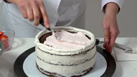 Front shot of a baker using an icing spa... | Stock Video | Pond5
