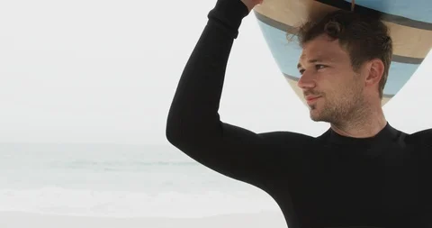 Front view of Caucasian male surfer carr... | Stock Video | Pond5