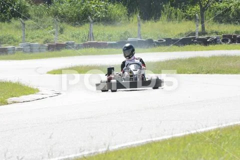 Front view of go-kart driver driving on race track on sunny day Stock ...