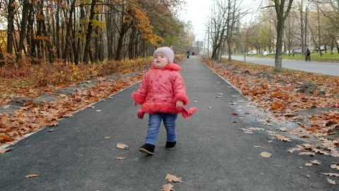 Front view of little girl walking along ... | Stock Video | Pond5