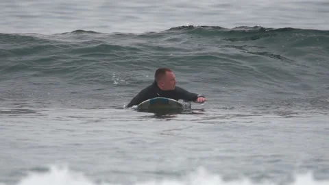 Front view of male surfer in wetsuit lyi... | Stock Video | Pond5