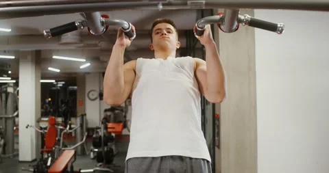 Front view of a young man doing pull-ups... | Stock Video | Pond5