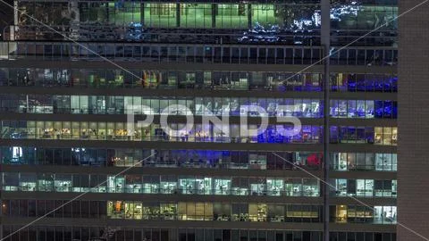 Frontal view of night facade of building with a lot of windows with ...