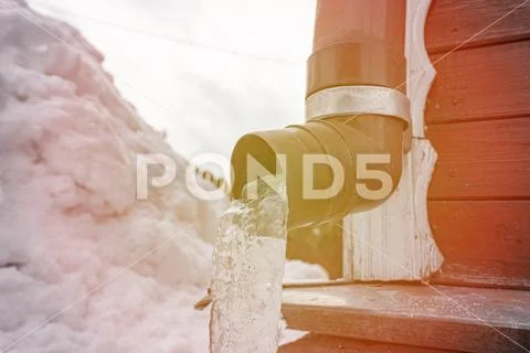 Frozen water in downspout gutter of the roof drainage system with ice ...