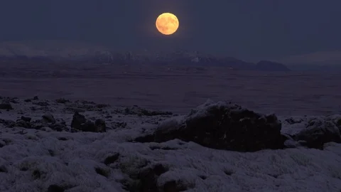 Full moon rising over frost covered lava... | Stock Video | Pond5