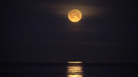 Full moon through hazy clouds reflecting... | Stock Video | Pond5