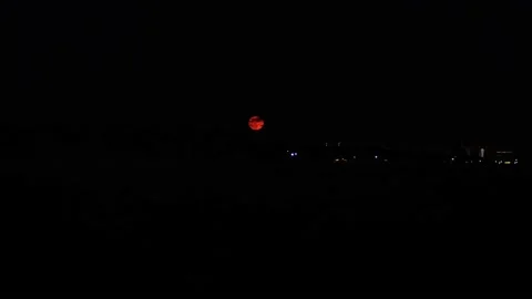 Full red moon over the night city in bla... | Stock Video | Pond5