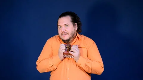 Funny fat man in orange shirt opens a bo... | Stock Video | Pond5