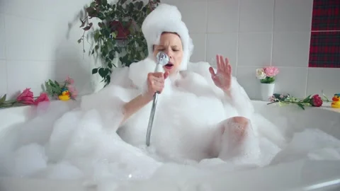 Funny girl sits in bath filled with foam... | Stock Video | Pond5